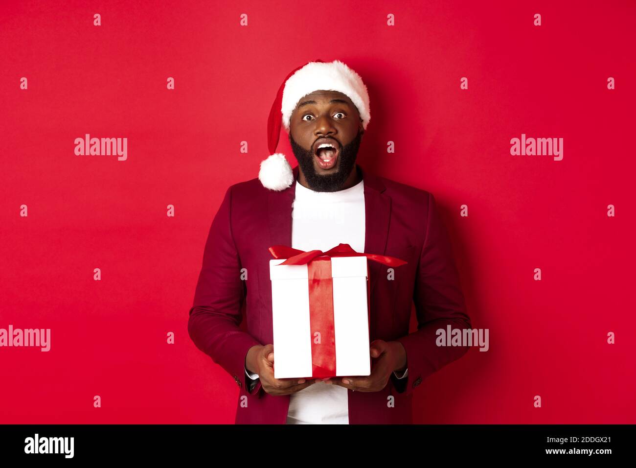 Christmas, New Year and shopping concept. Excited Black man receiving ...