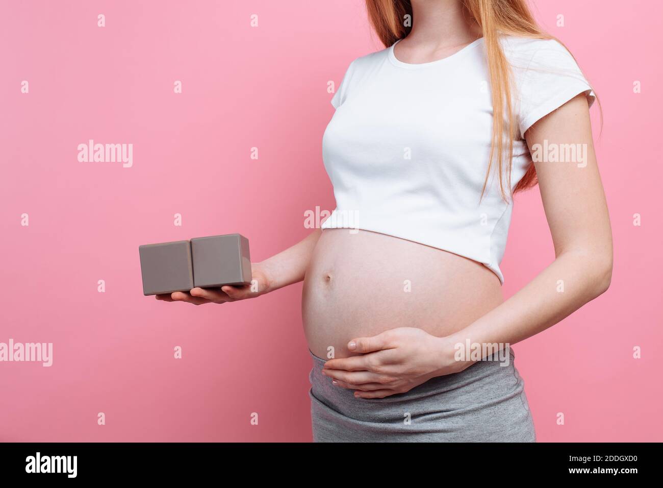 Macro image of a pregnant woman holding wooden cubes near the belly, 9 ...