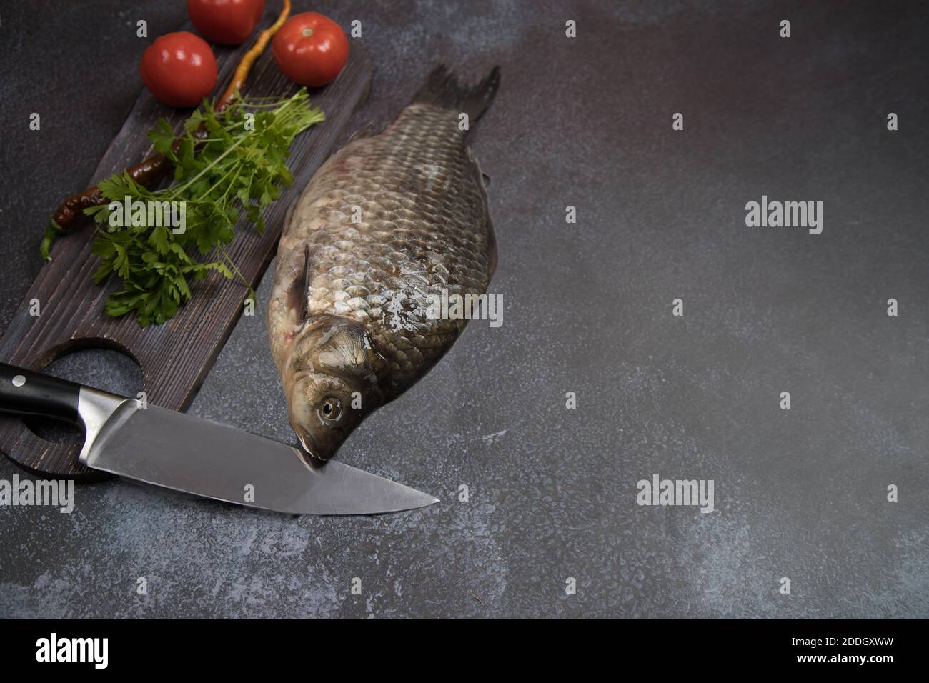 Raw carp fish before frying on a dark background Stock Photo - Alamy
