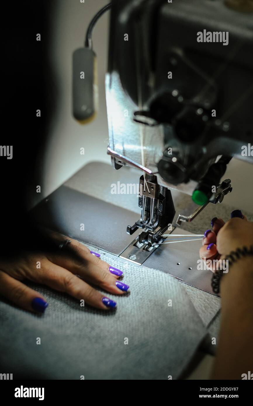 A vertical shot of female hands using a sewing machine Stock Photo - Alamy