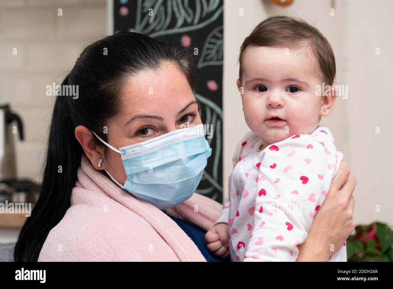 Female model as sick mother wearing medical or surgical mask to prevent ...