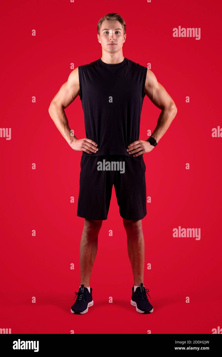 Full length portrait of determined male fitness model looking at camera ...