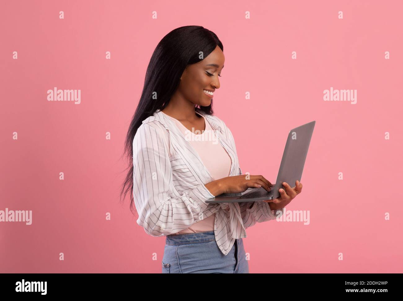 Millennial African American woman working with laptop computer, working ...