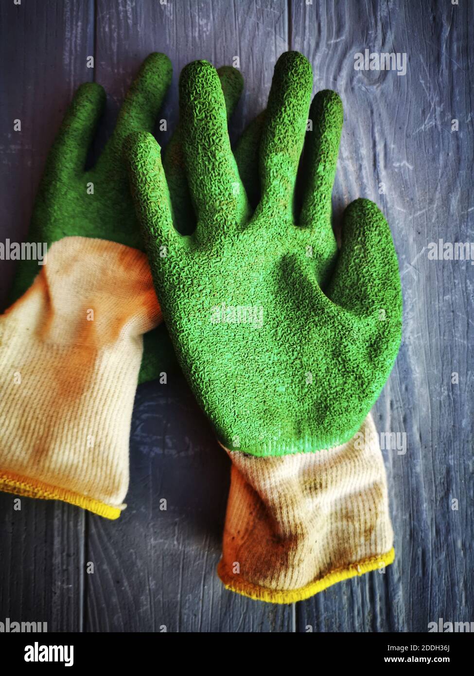 A vertical closeup of old dirty gloves on wooden background Stock Photo ...