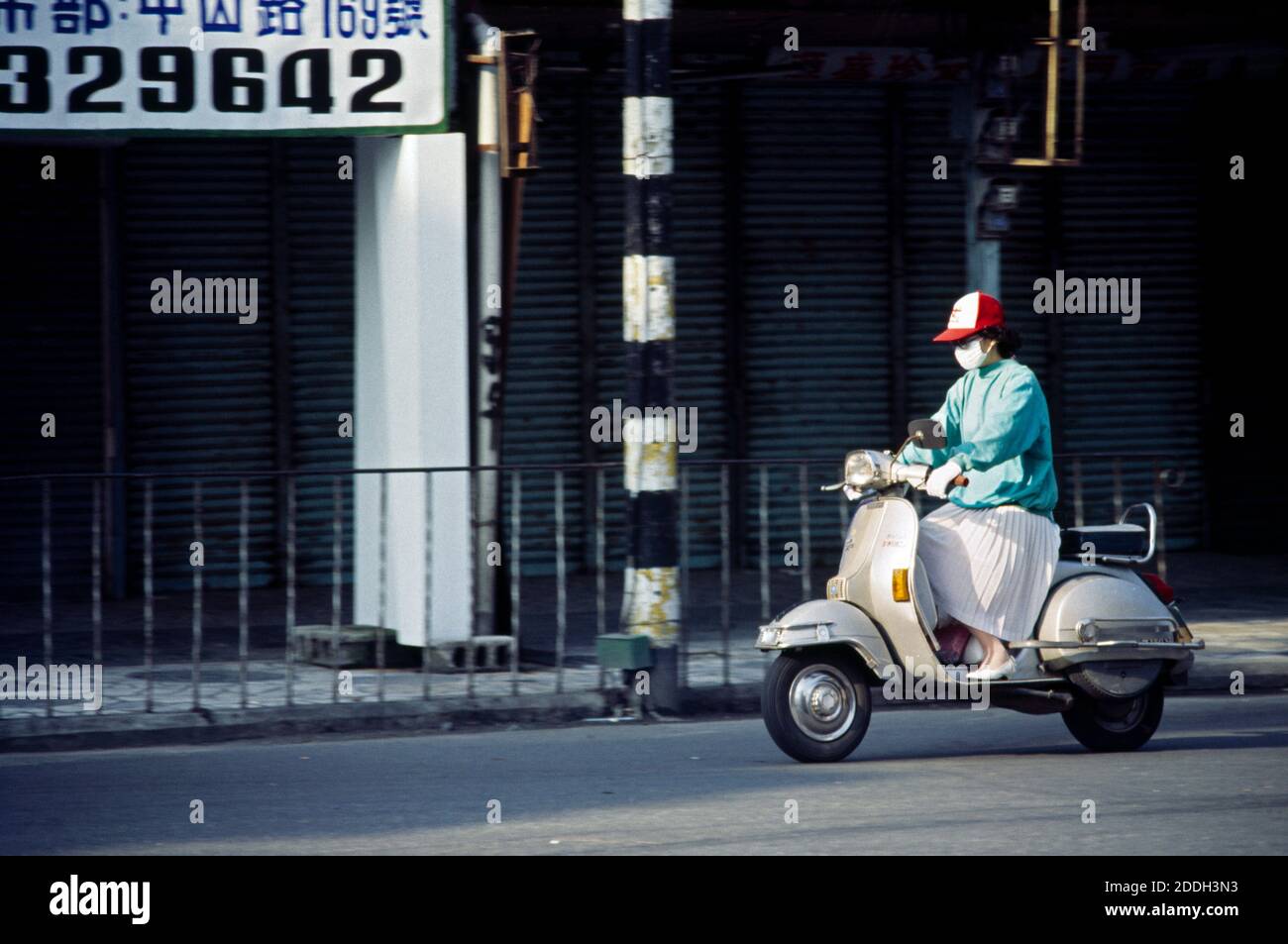 Taipei Taiwan Woman driving a moped wearing a anti pollution mask Stock ...