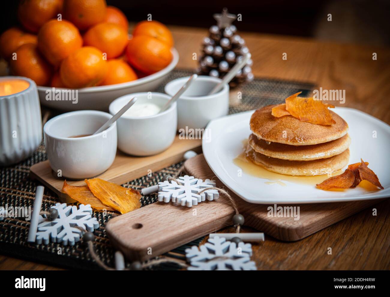 Decorated Christmas dish on breakfast with pancakes and tangerines on ...