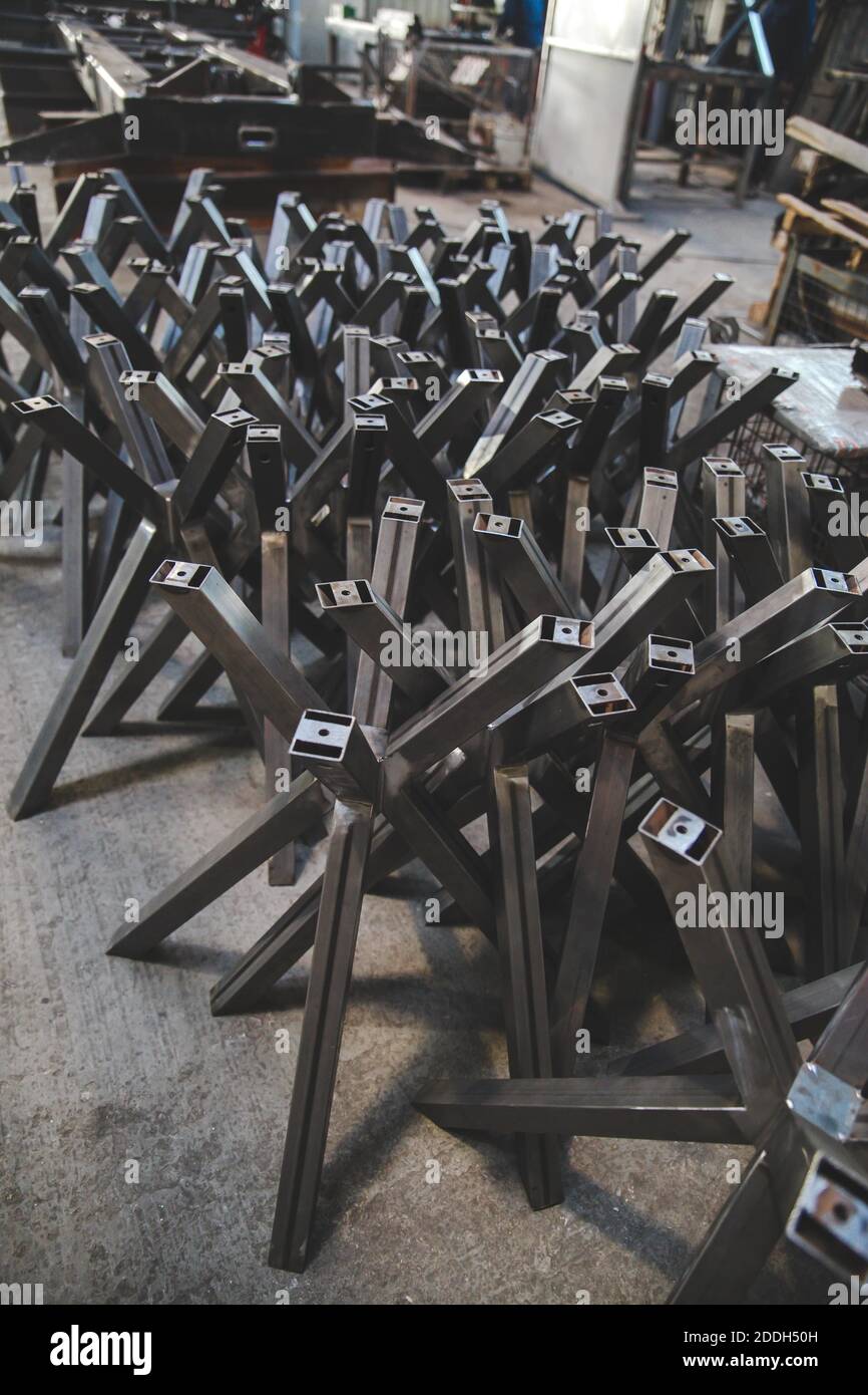 A stack of metal table stands in a factory Stock Photo - Alamy