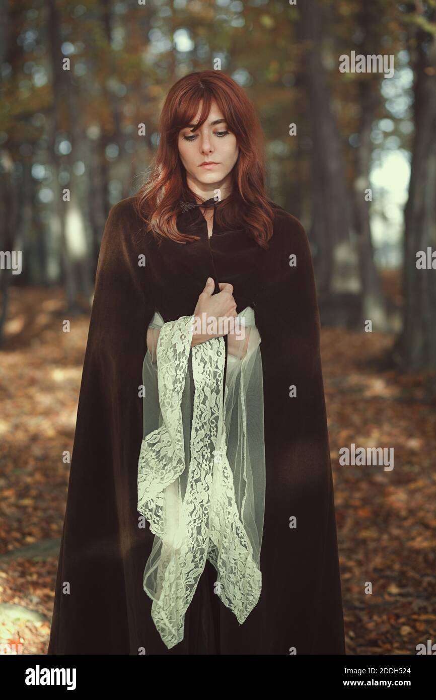 Beautiful woman alone in the forest. Medieval dress and cloak Stock ...