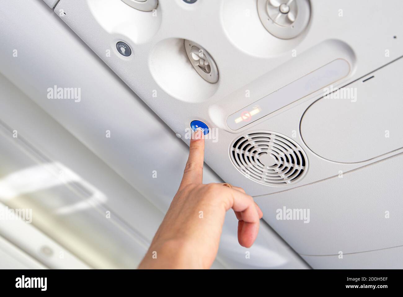 Passenger pressing the button to call cabin crew, stewardess for a ...