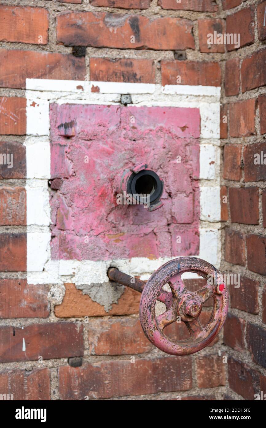 Old water outlet on red brick building wall in Konepaja district of ...