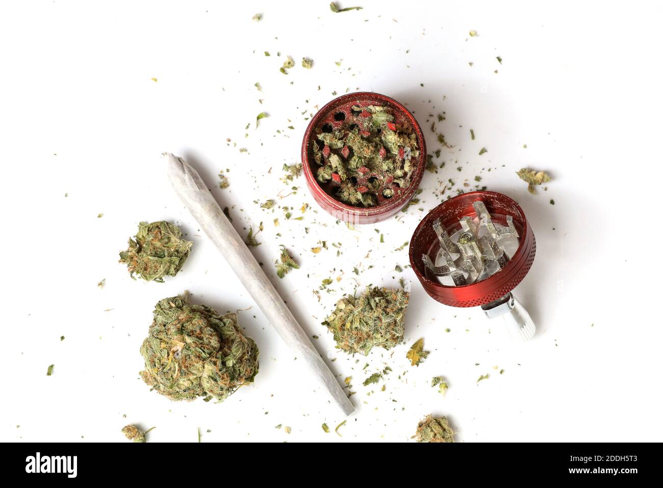 Cannabis branch, joint and red grinder isolated on a white background ...