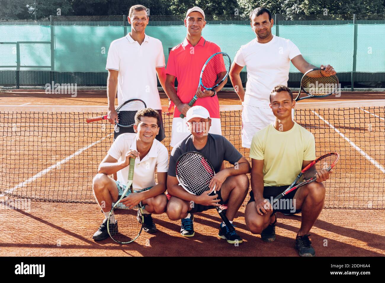 Group of six male tennis players standing on court Stock Photo - Alamy