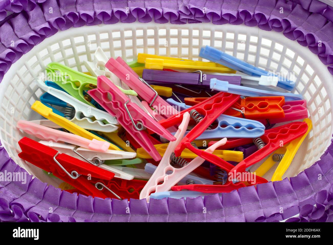 Multi colored clothes pegs in the basket Stock Photo - Alamy