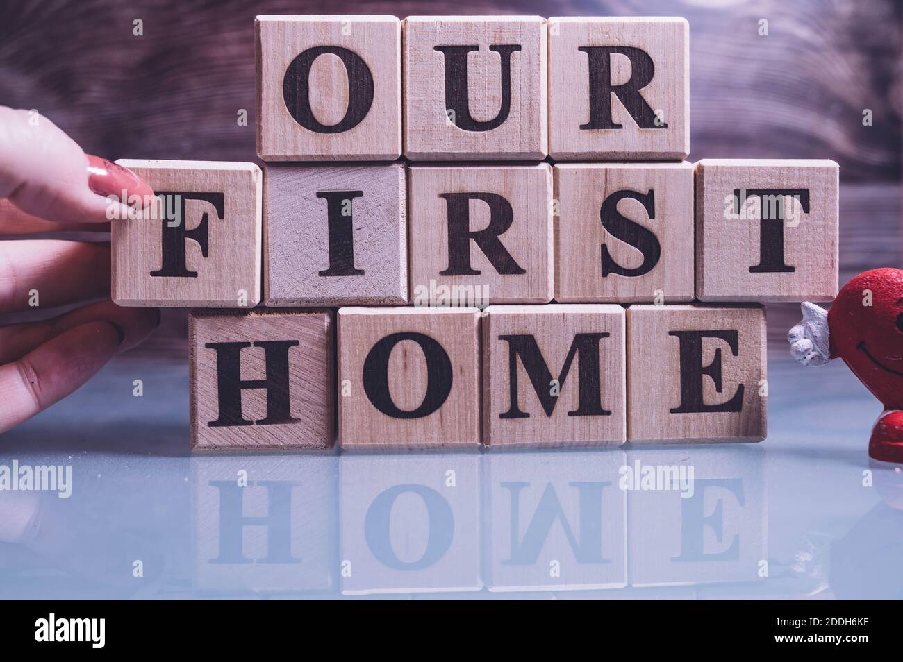 Text OUR FIRST HOME on wood cube blocks. The letters OUR FIRST HOME ...