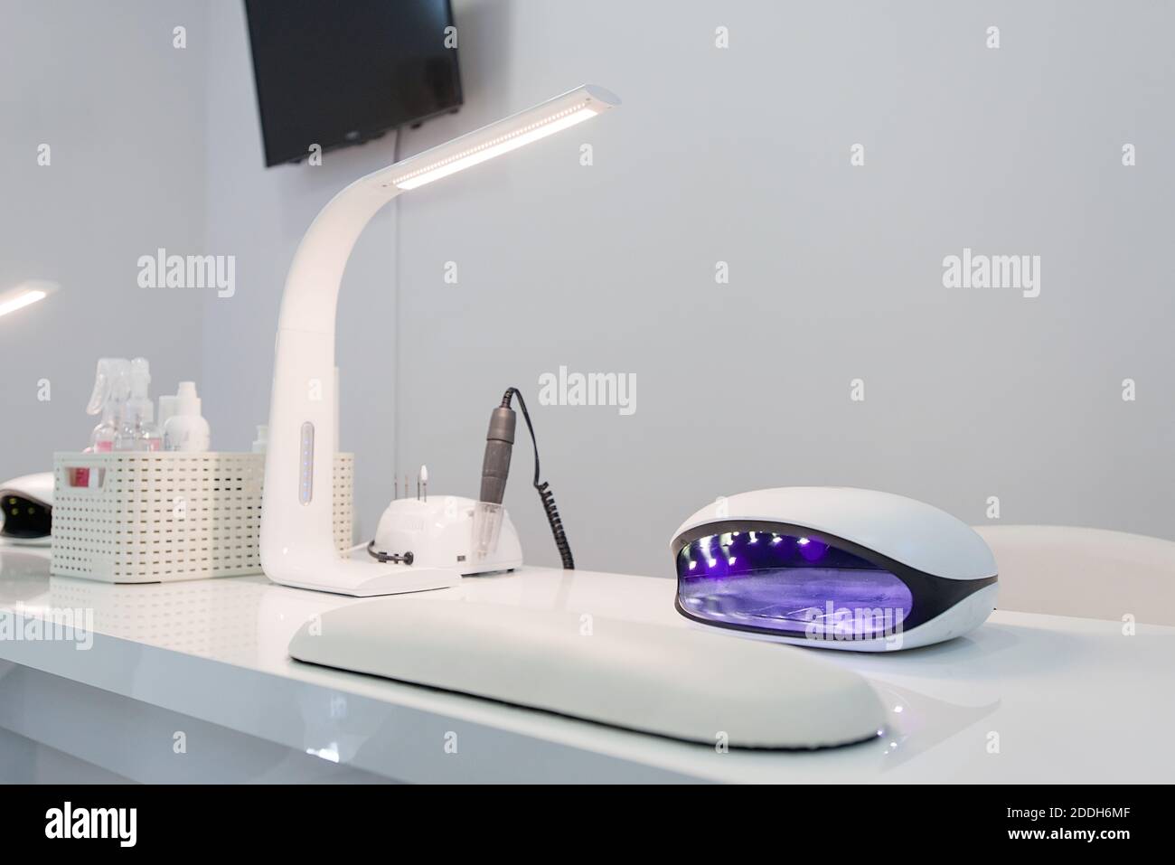 Manicure. White lamp on white table with nail tool Stock Photo - Alamy