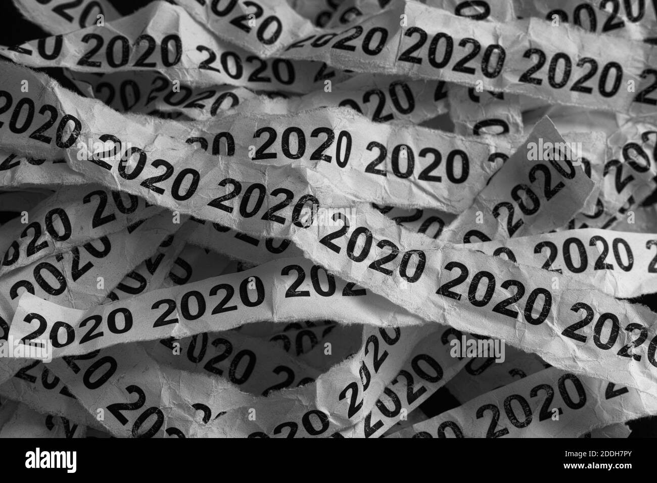 Strips of newspaper with the year 2020 typed on them. Black and white ...