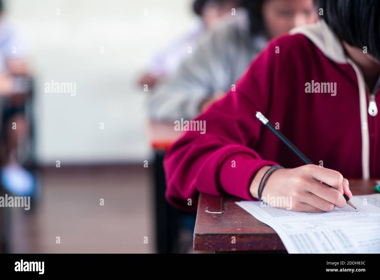 Students writing and reading exam answer sheets exercises in classroom ...