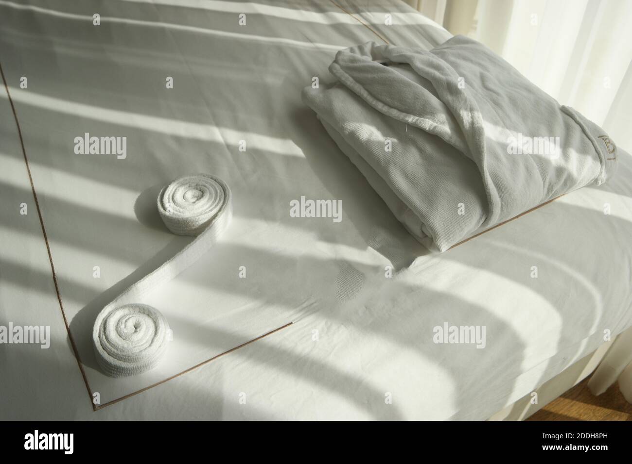 Folded white bathrobe on the bed in hotel room. Clean folded bathrobe ...