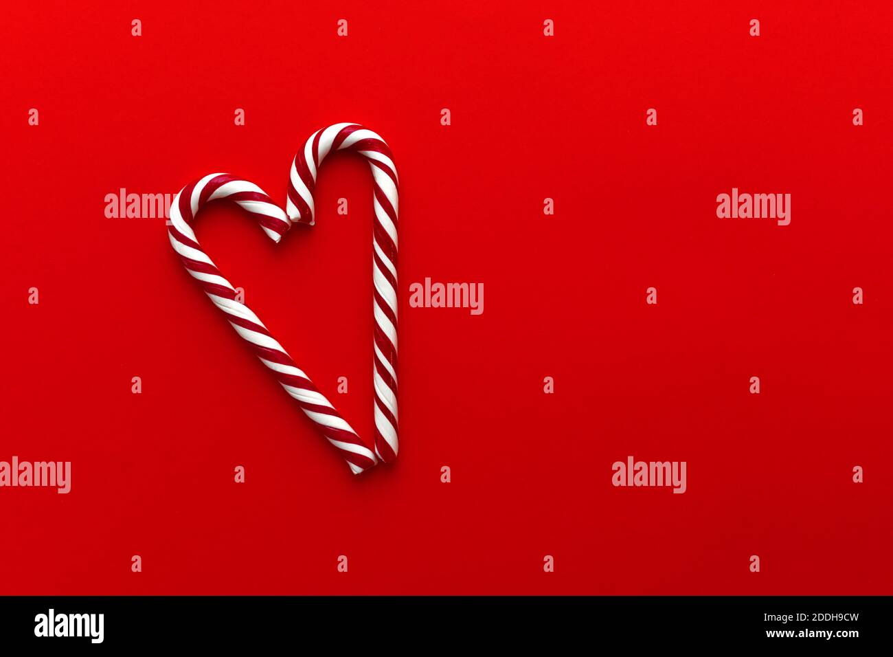 Two candy canes making a heart on a red textured background, Candy cane ...