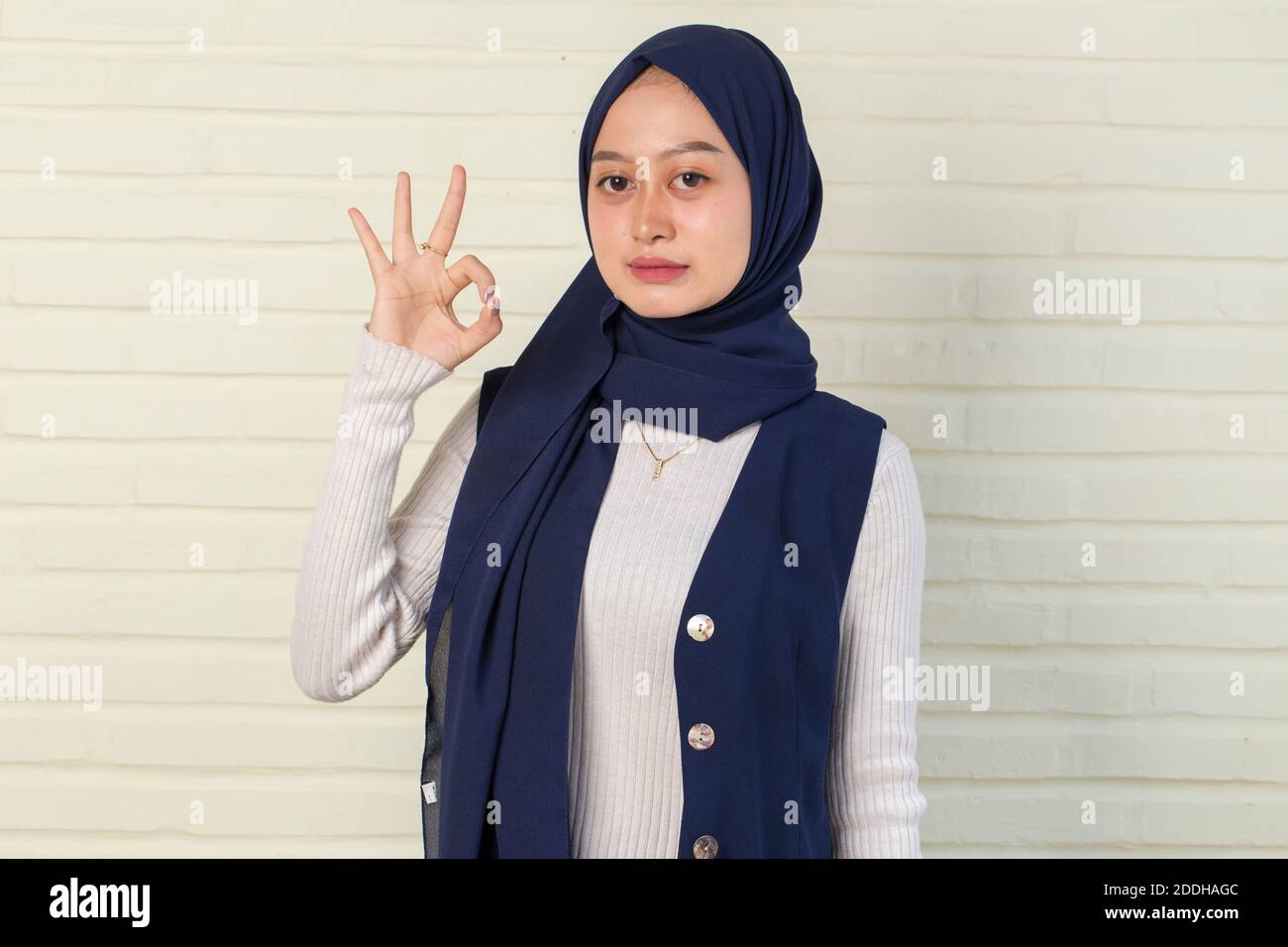Asian muslim woman wearing hijab with ok sign gesture Stock Photo - Alamy