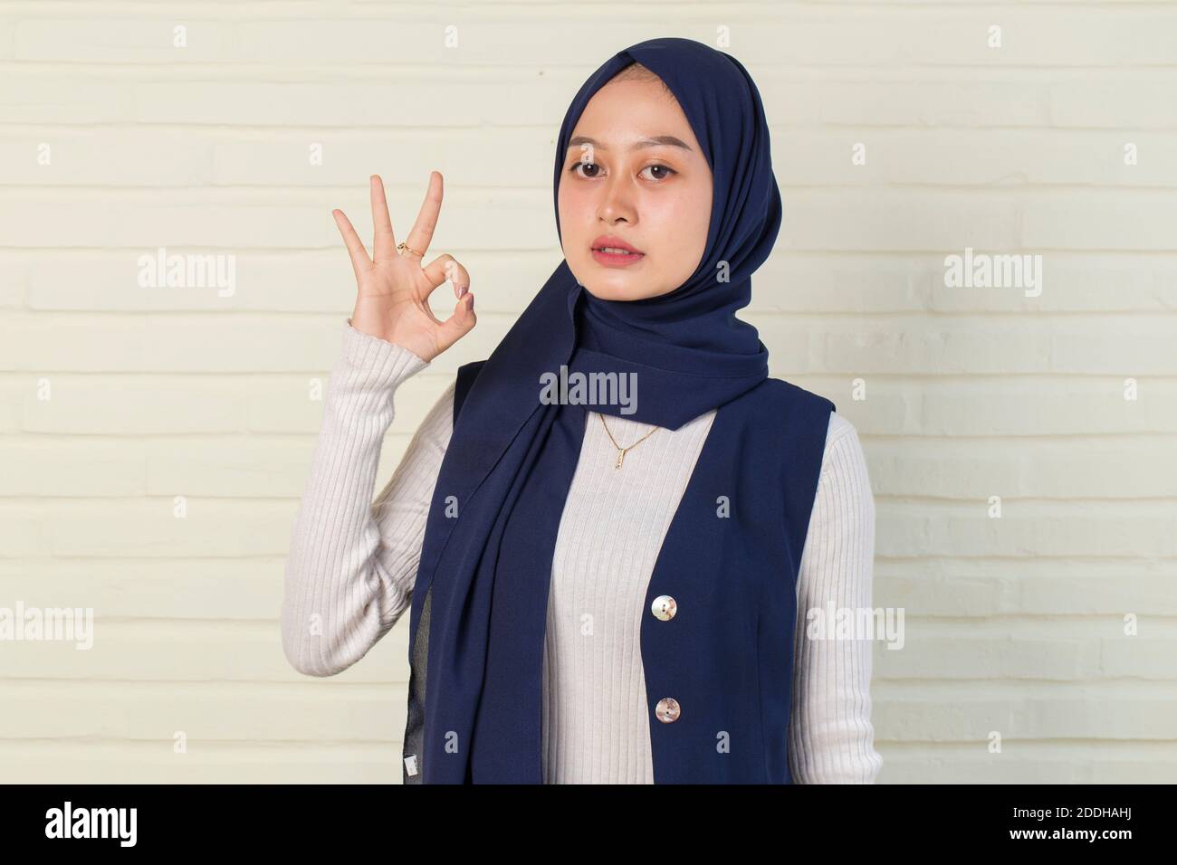 Asian muslim woman wearing hijab with ok sign gesture Stock Photo - Alamy