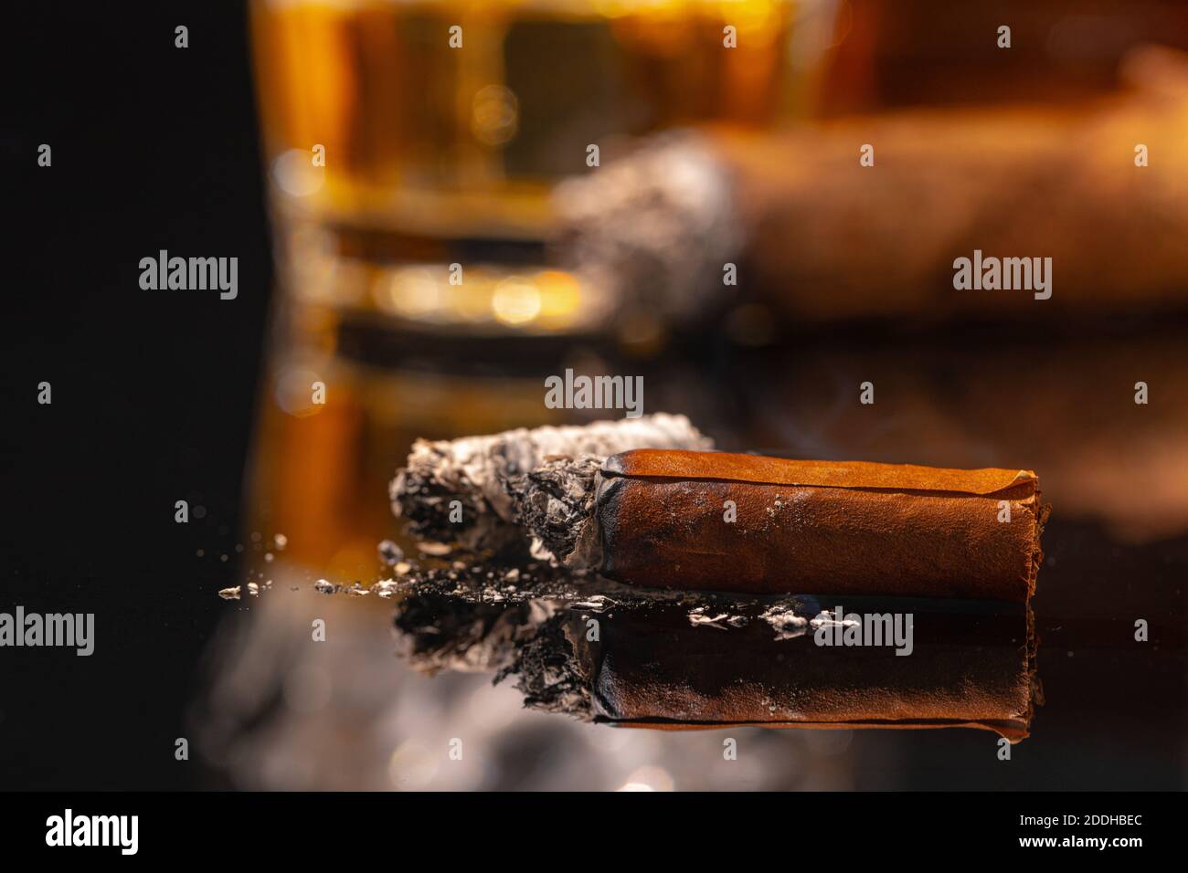 Glass of whisky and lighted cigar on black background Stock Photo - Alamy