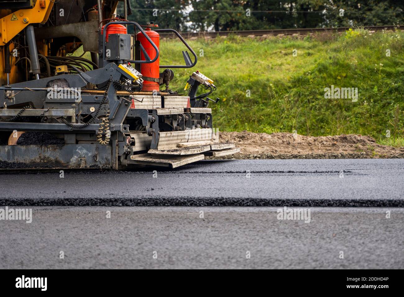 Industrial asphalt paver machine laying fresh asphalt on road ...