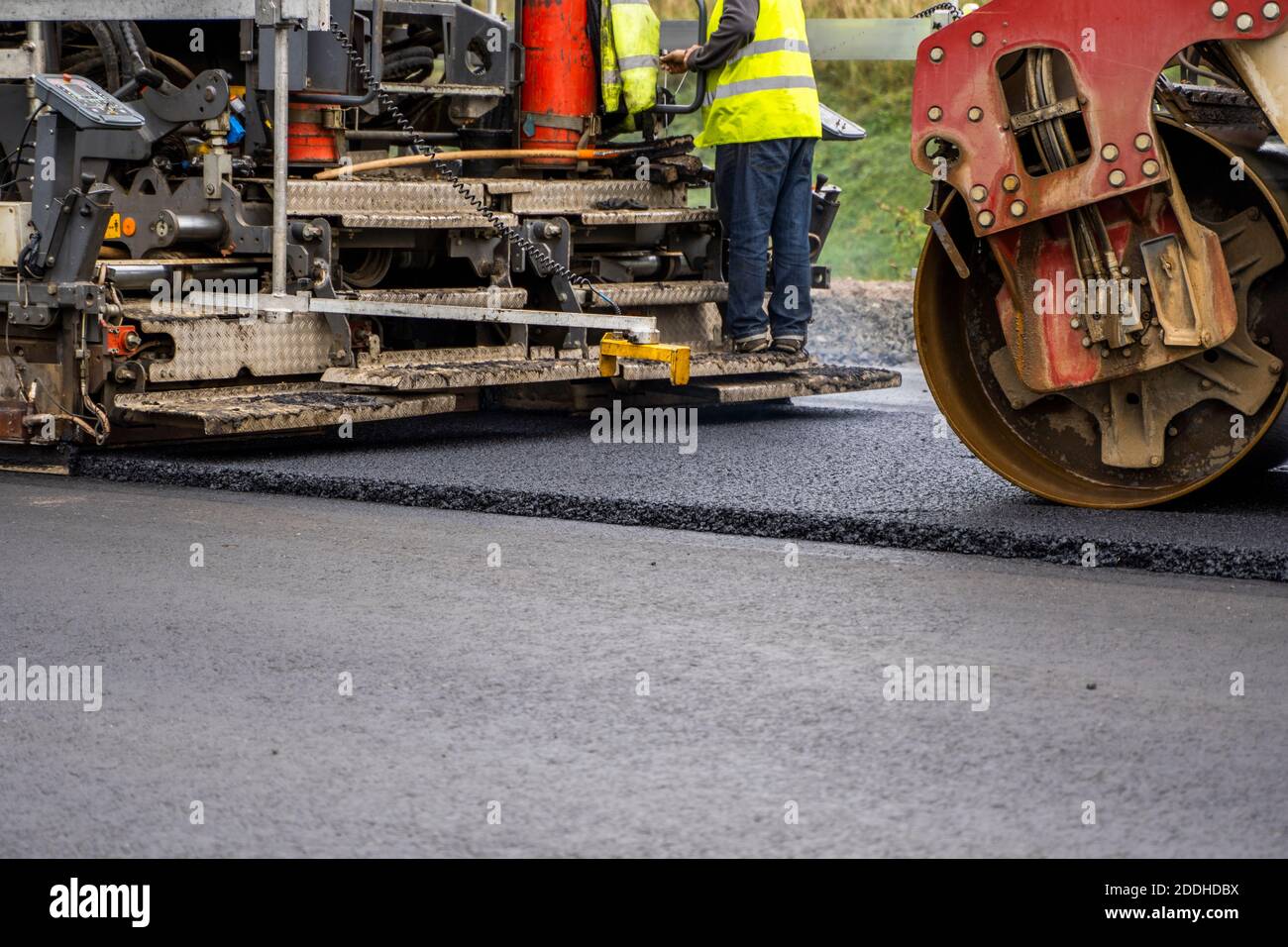 Industrial asphalt paver machine laying fresh asphalt on road ...