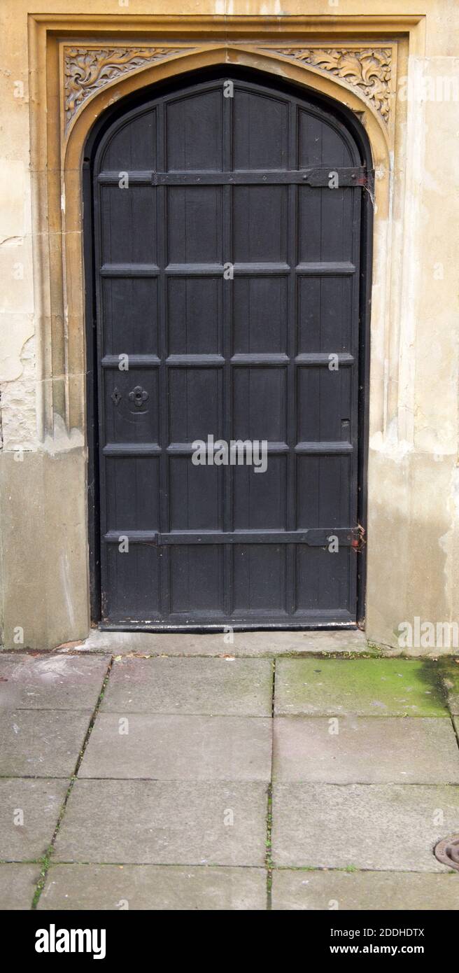 Old fashioned English wooden panelled door with ornate stone detail on ...