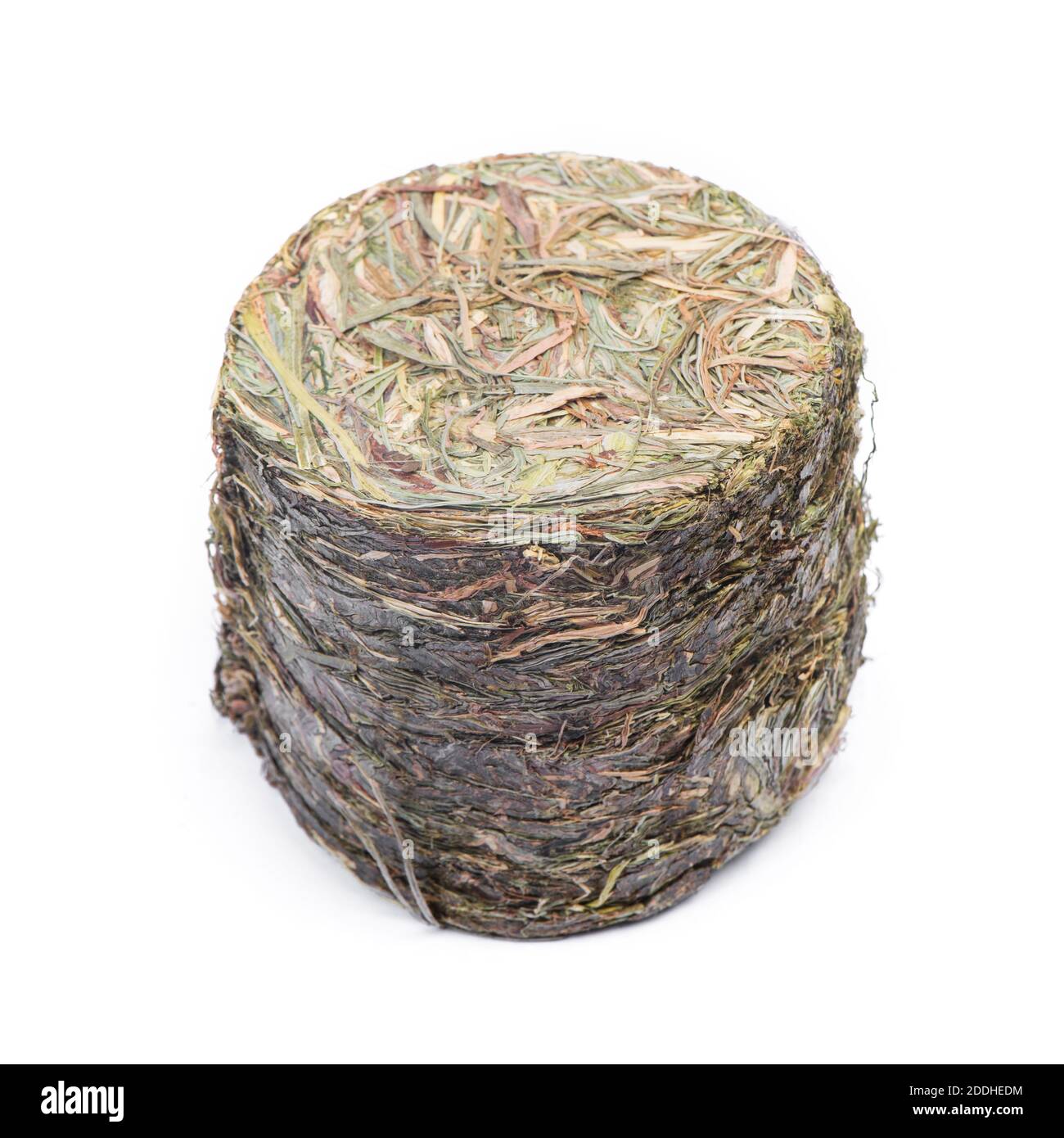 Pressed grass, hay in small cylinder isolated over white background ...