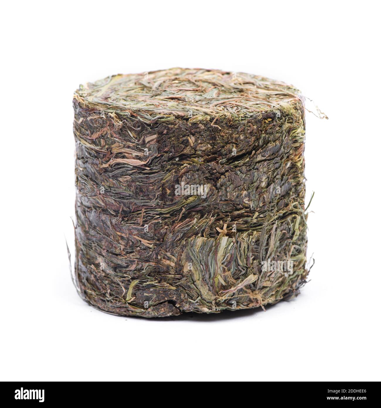 Pressed grass, hay in small cylinder isolated over white background ...