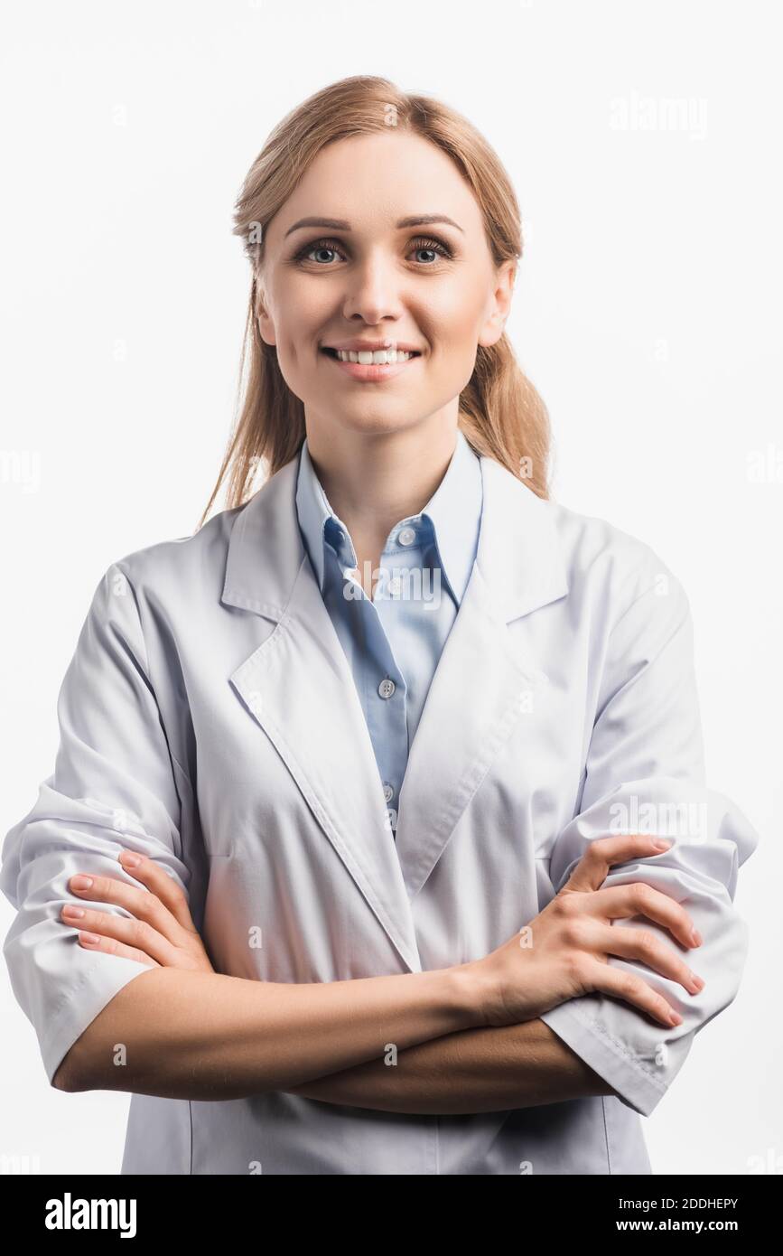 positive nurse in white coat standing with crossed arms isolated on ...
