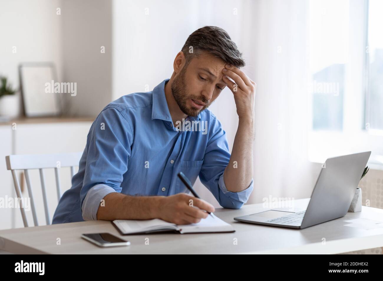 Busy Businessman Taking Notes To Notepad While Working With Laptop At ...