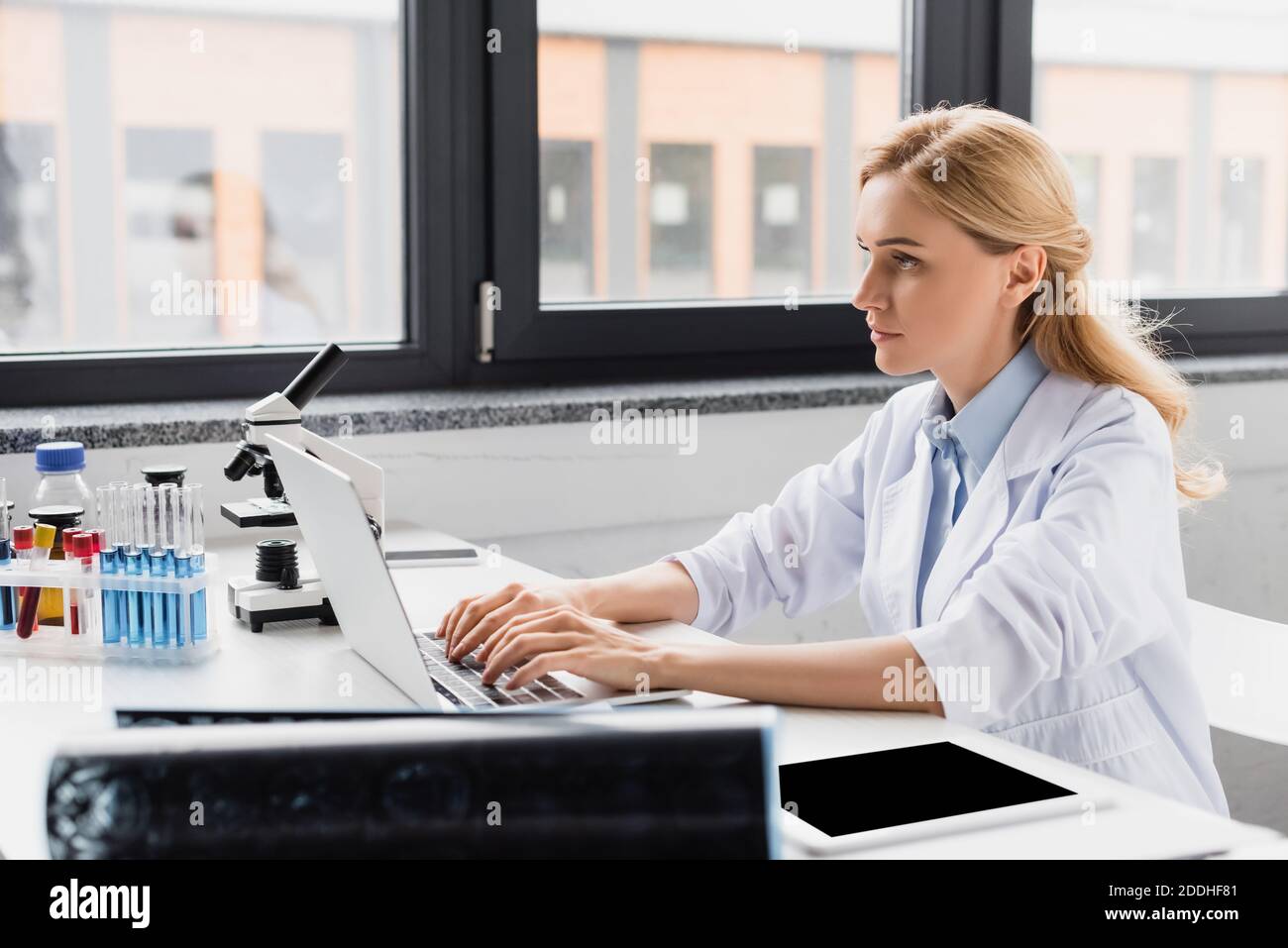 scientist using laptop near microscope and devices in lab Stock Photo ...