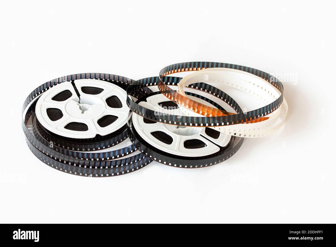 Two 8mm film reels with film strips scattered around. Studio shot ...