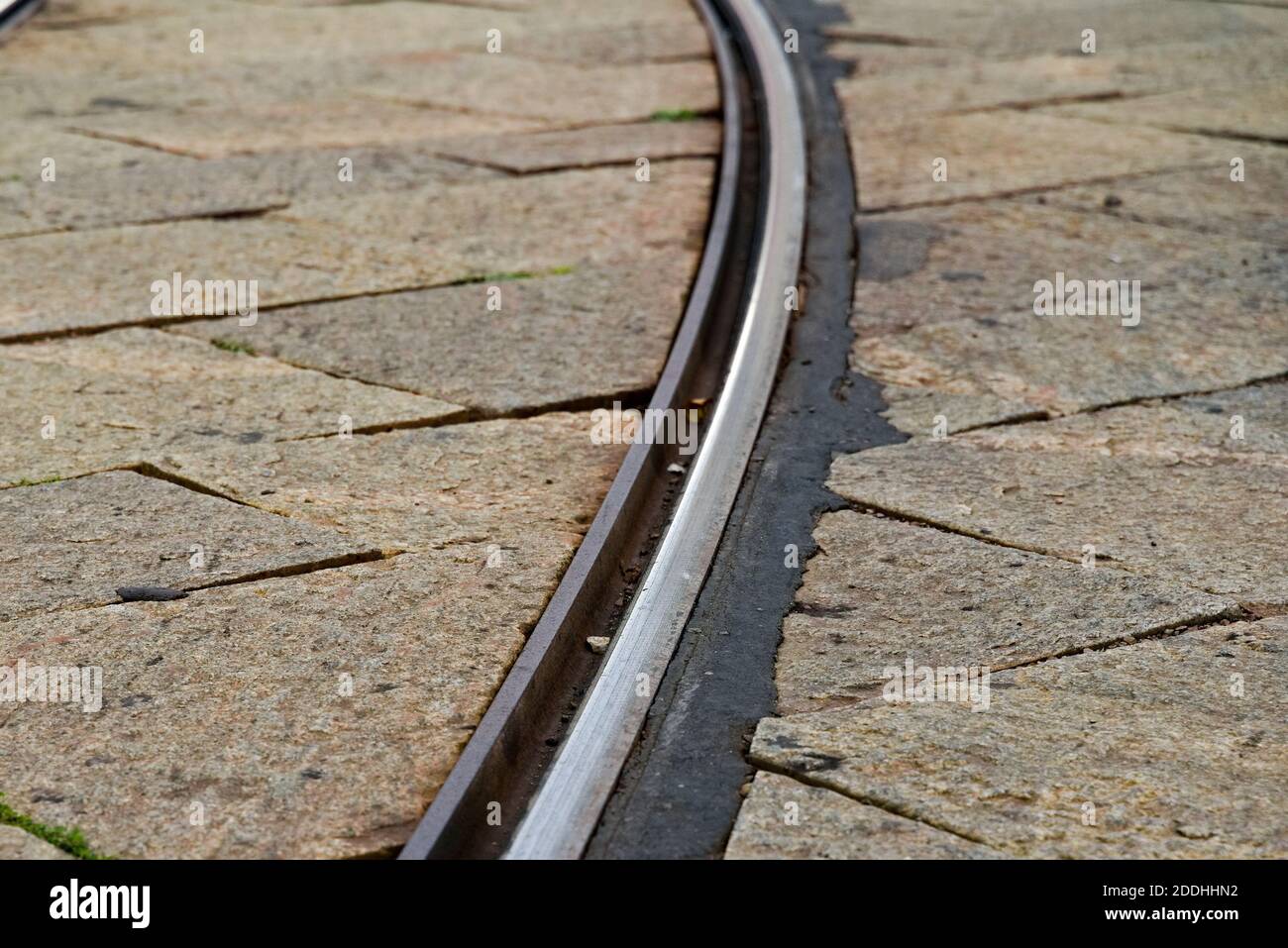 Railroad tracks in paved road, close up Stock Photo - Alamy