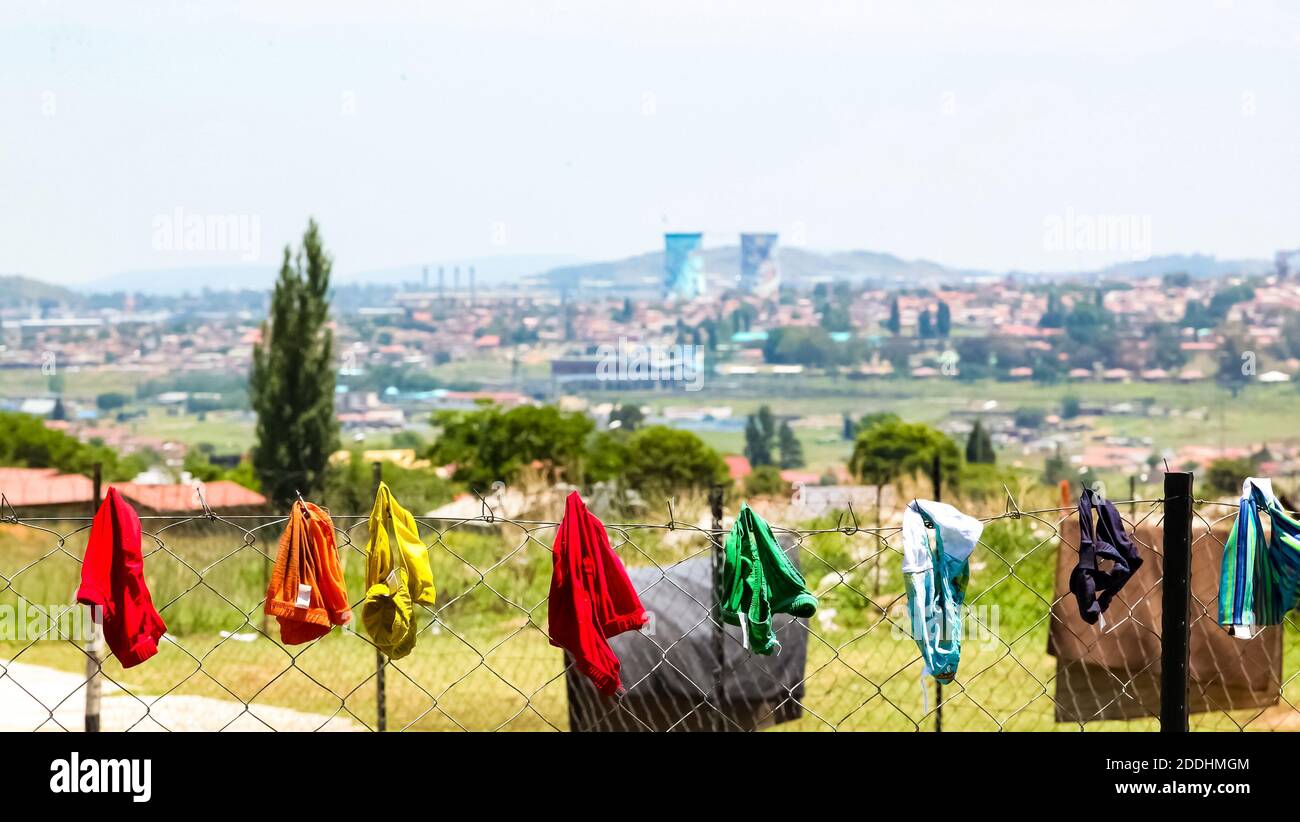 A lot of different clothes hanging on a fence in a suburban area Stock ...