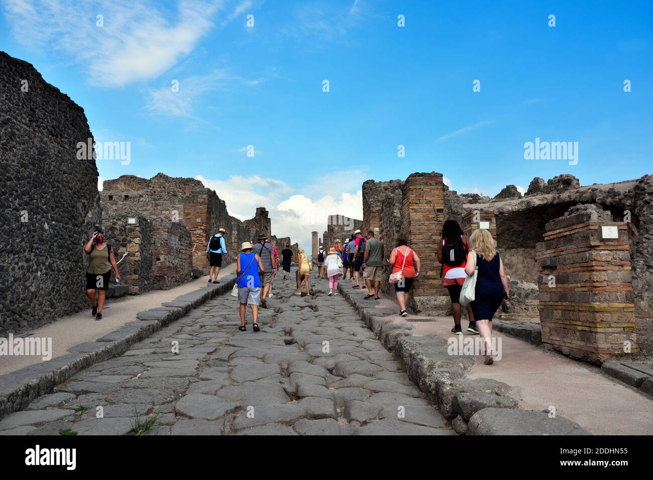groups of tourists with masks in the ruins of the ancient Roman city ...