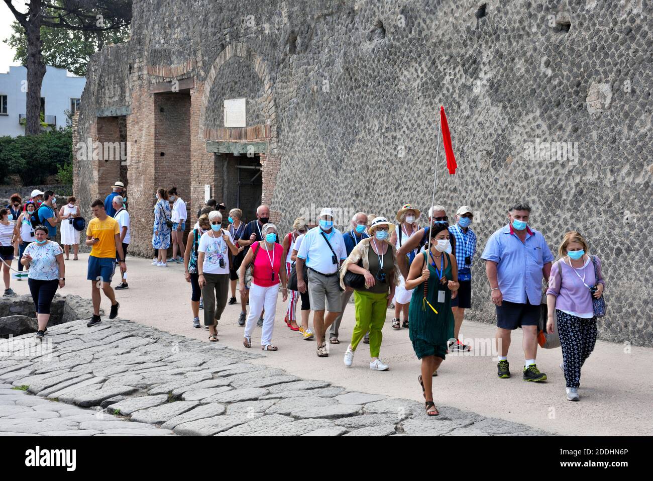 groups of tourists with masks in the ruins of the ancient Roman city ...