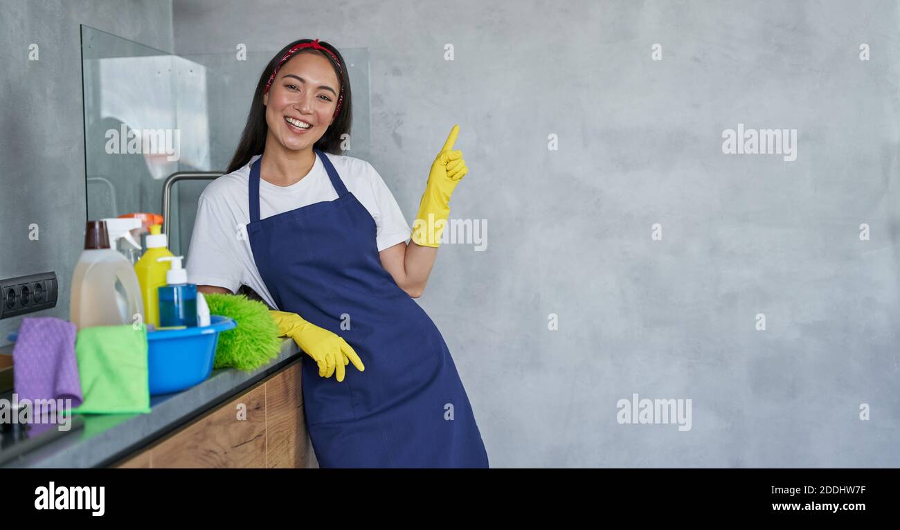 Cheerful young woman, cleaning lady in protective gloves smiling at ...