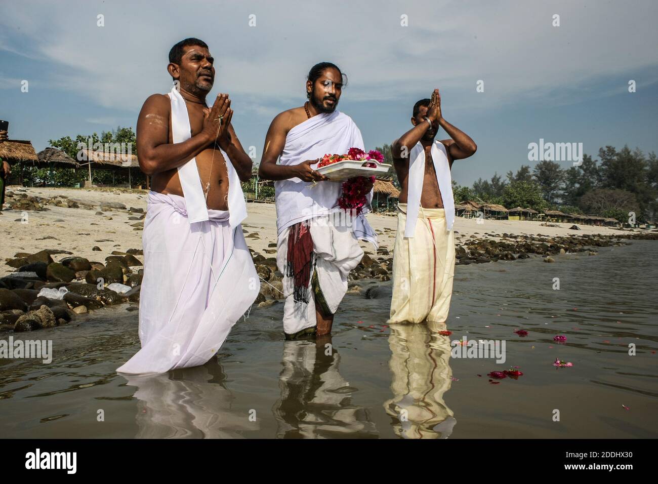 Devotees offering prayers while standing in water during the rituals ...