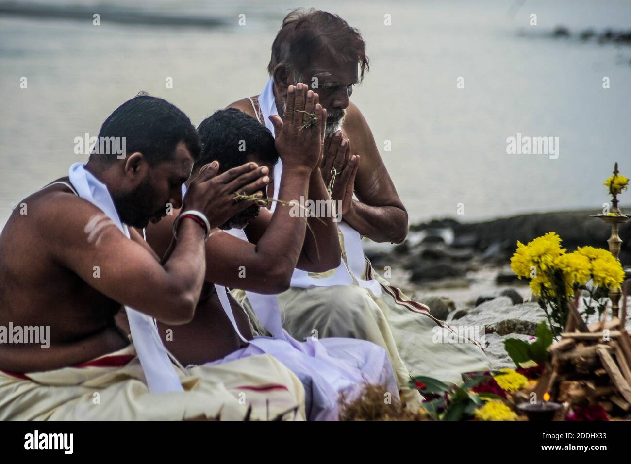 Devotees offering prayers while sitting on the ground during the ...