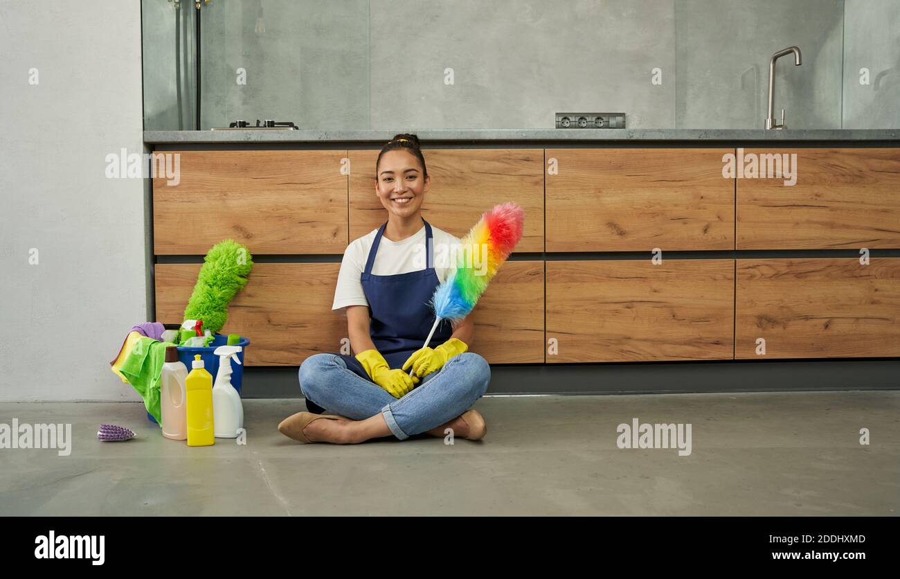 Safe and clean. Joyful young woman smiling at camera, holding cleaning ...