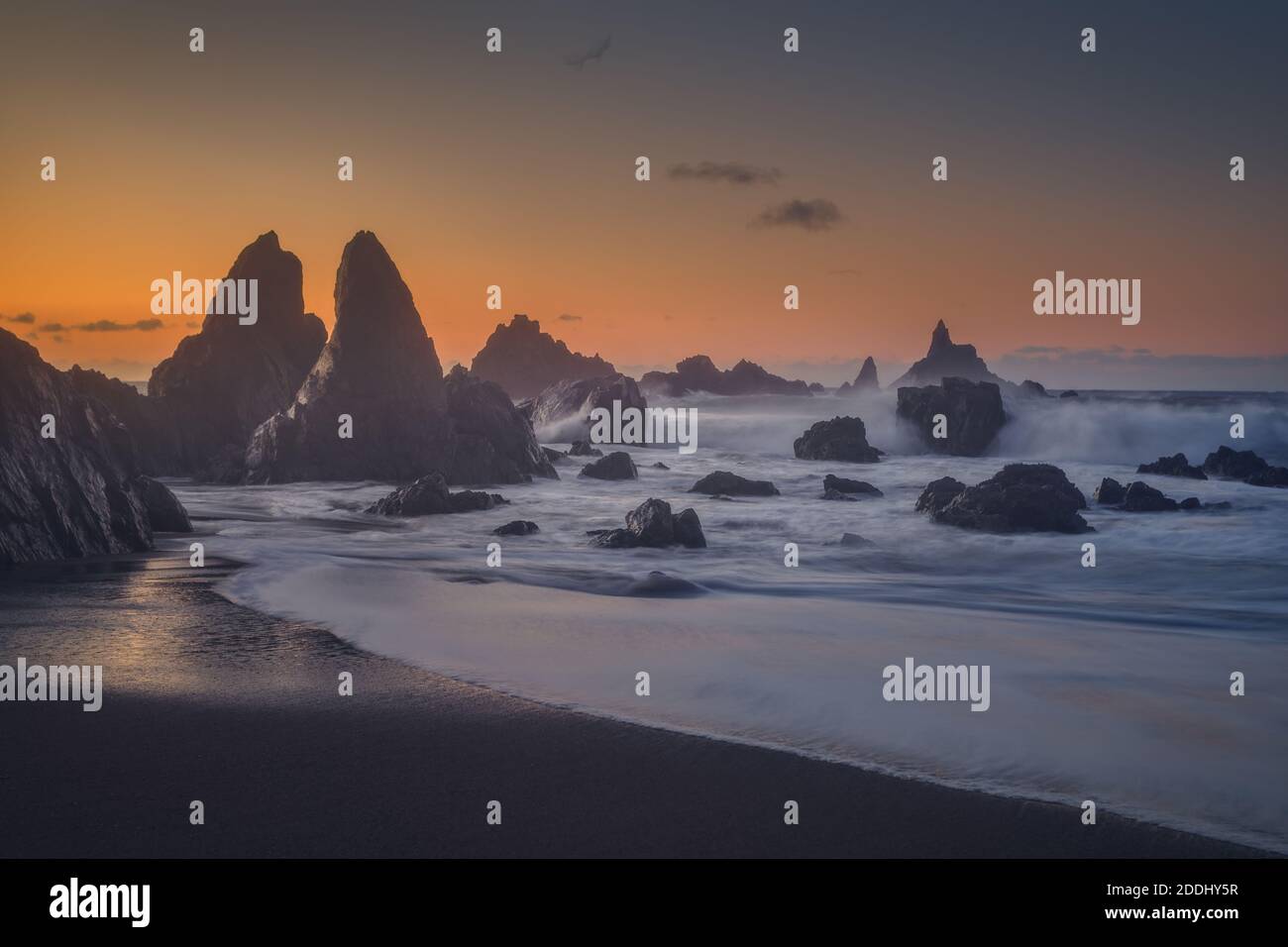 The rock formations in the foamy water of the sea at sunset Stock Photo ...