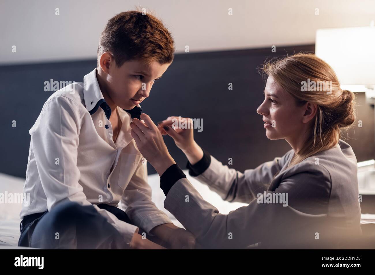 A Mother helping her son to get ready for school, fixing his collar Stock Photo - Alamy