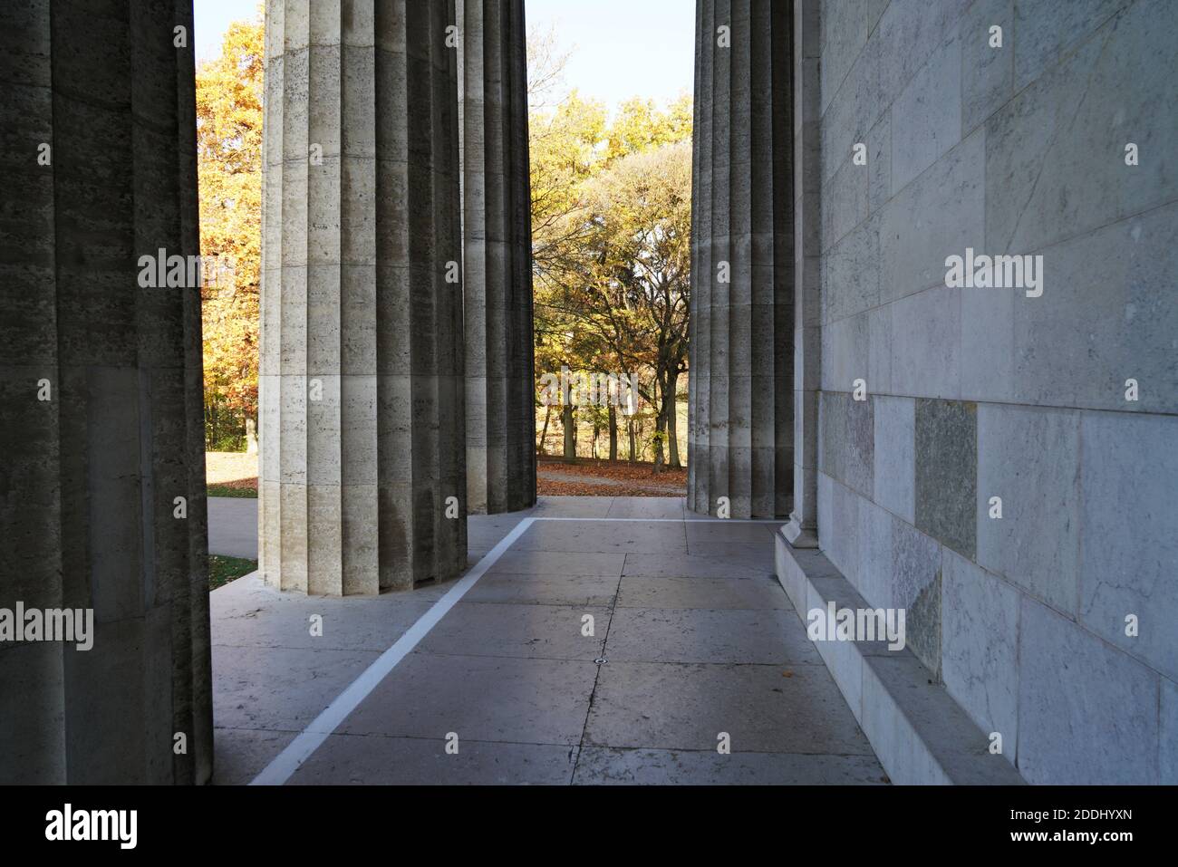 A closeup view of a long corridor with columns and direct sunlight on ...