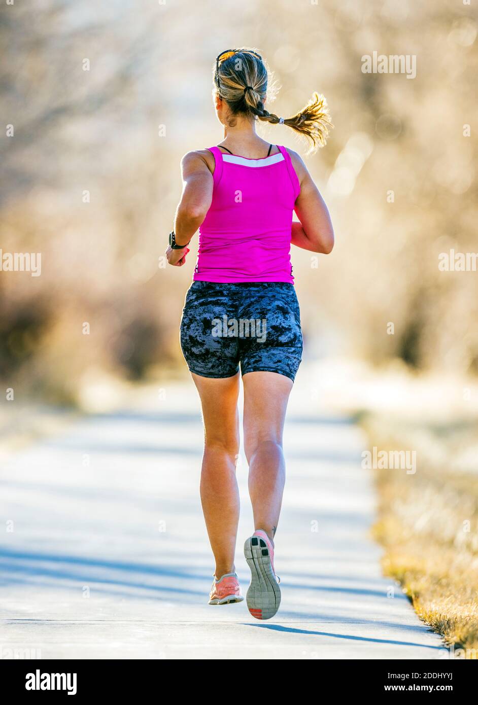 Attractive; middle-aged; fit woman running on paved trail; Salida ...