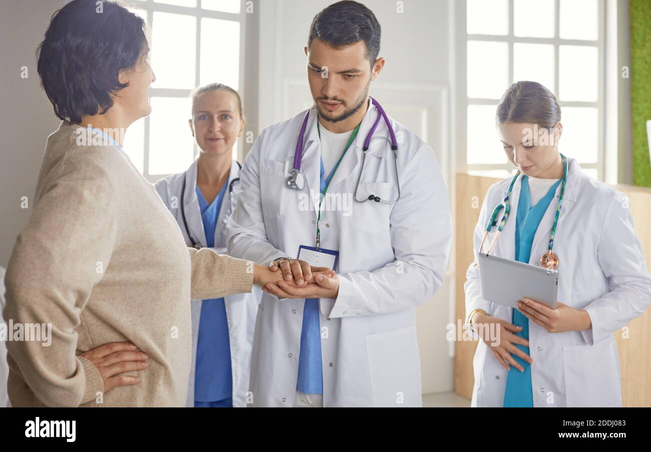 Patient with a group of doctors at the background Stock Photo - Alamy