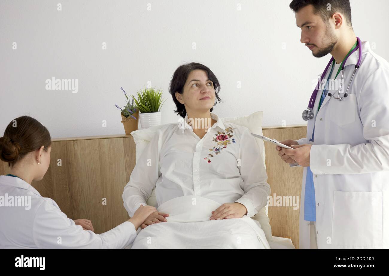 Patient with a group of doctors at the background Stock Photo - Alamy