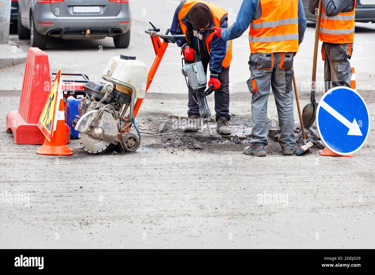 Road workers in reflective clothing on a fenced-in section of road ...